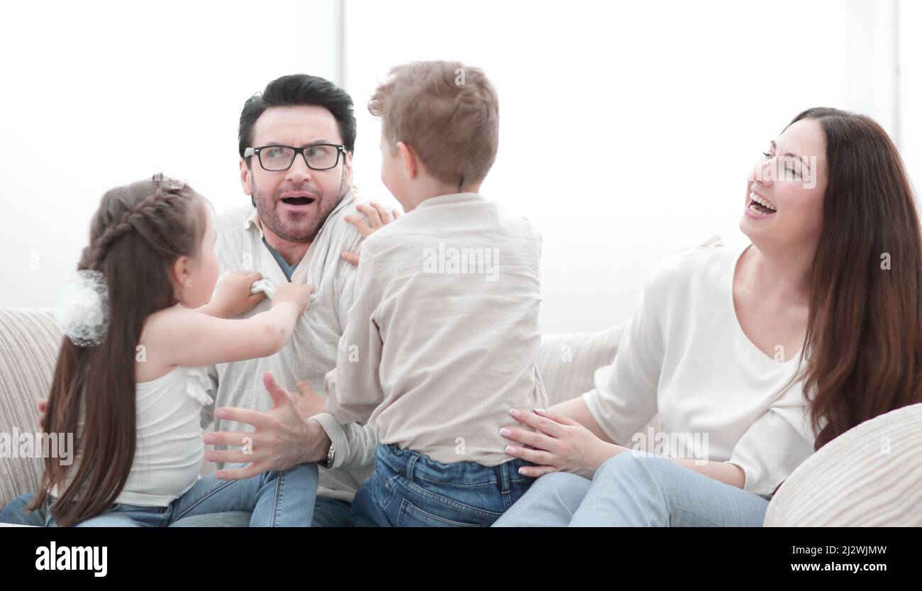 parents play with children sitting on the couch Stock Photo - Alamy
