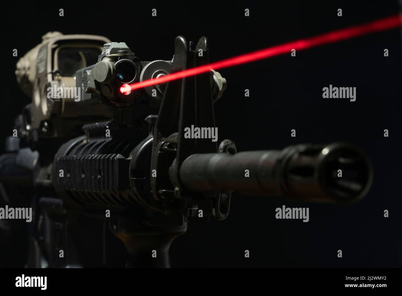 Optical sight and laser device with a red beam on the M4 rifle on dark ...