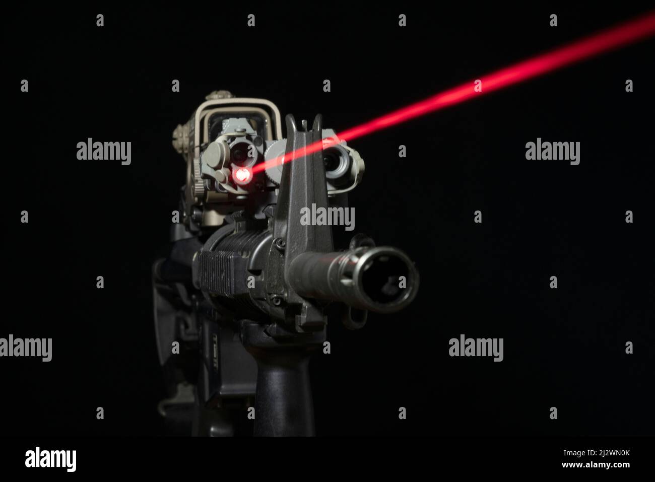 Optical sight and laser device with a red beam on the M4 rifle on dark ...