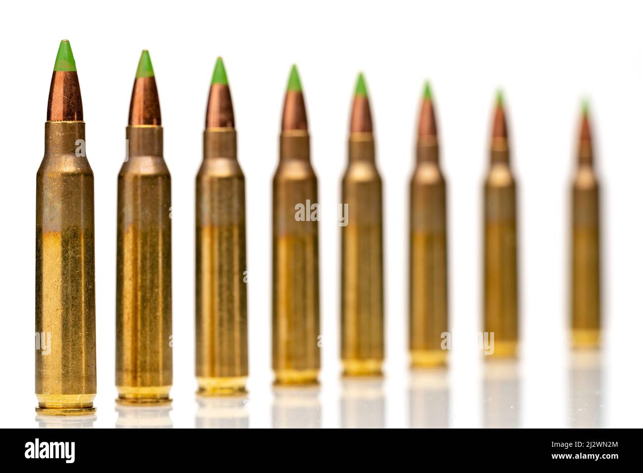 A group of 5.56 calibar, green tip bullets ordered into the line on ...