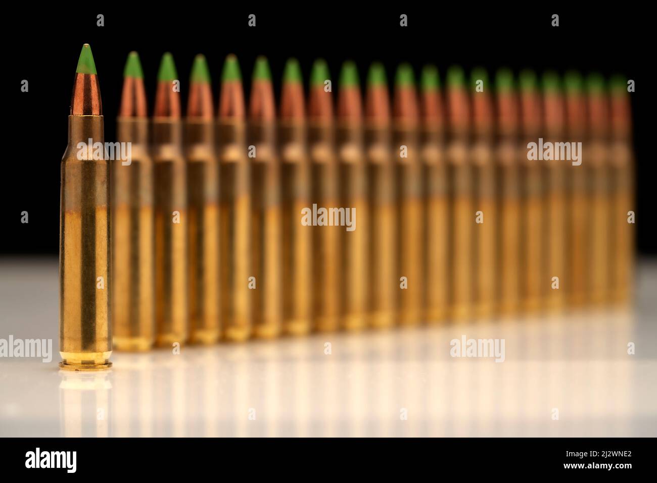 A group of 5.56 calibar, green tip bullets ordered into the line on ...