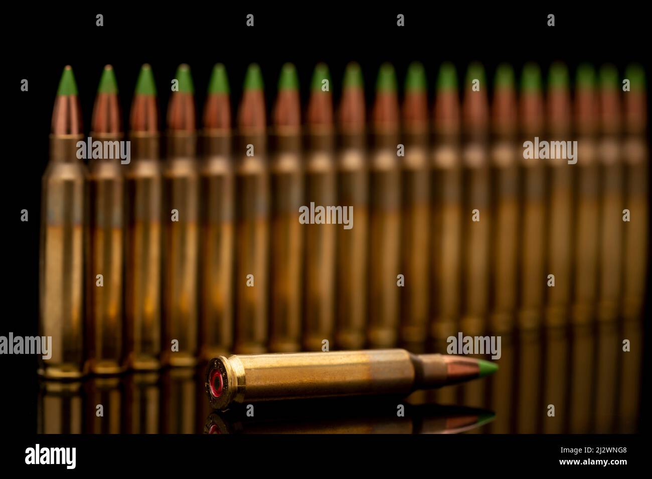 A group of 5.56 calibar, green tip bullets ordered into the line on ...