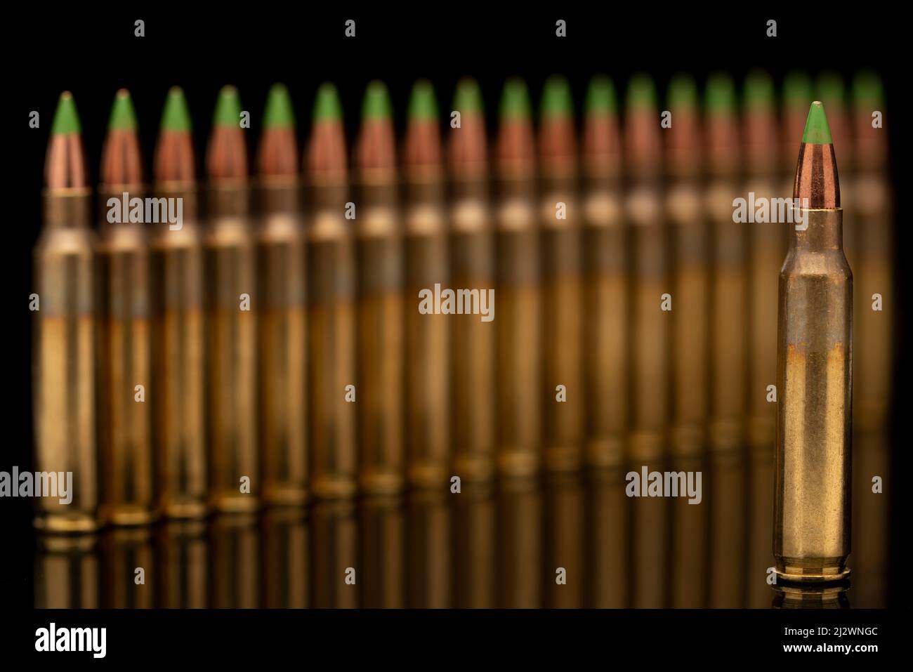 A group of 5.56 calibar, green tip bullets ordered into the line on ...