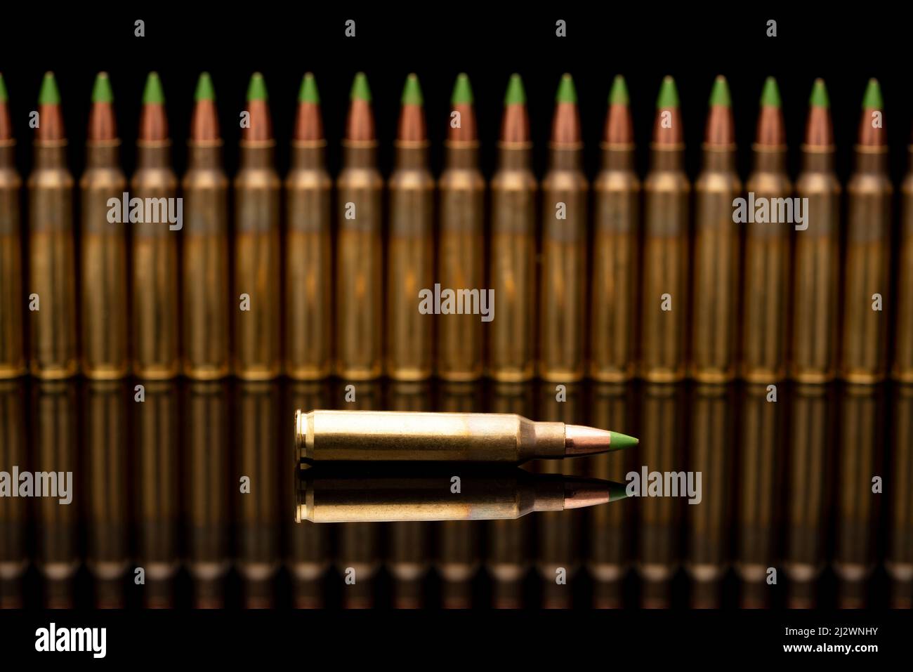 A group of 5.56 calibar, green tip bullets ordered into the line on ...