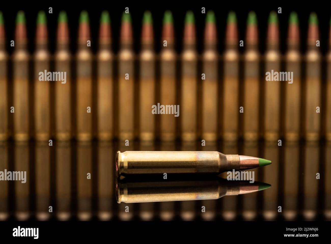 A group of 5.56 calibar, green tip bullets ordered into the line on ...