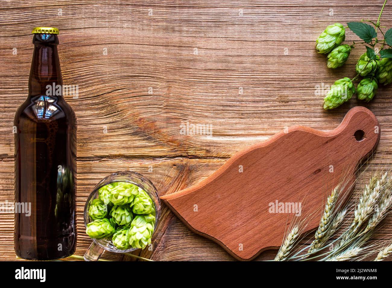 Dark bottle of beer, hops, malt on an old wooden table Stock Photo - Alamy