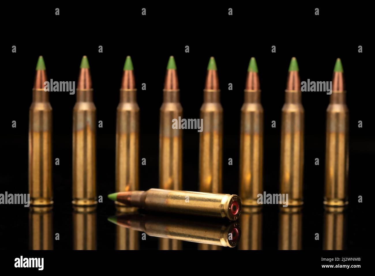 A group of 5.56 calibar, green tip bullets ordered into the line on ...
