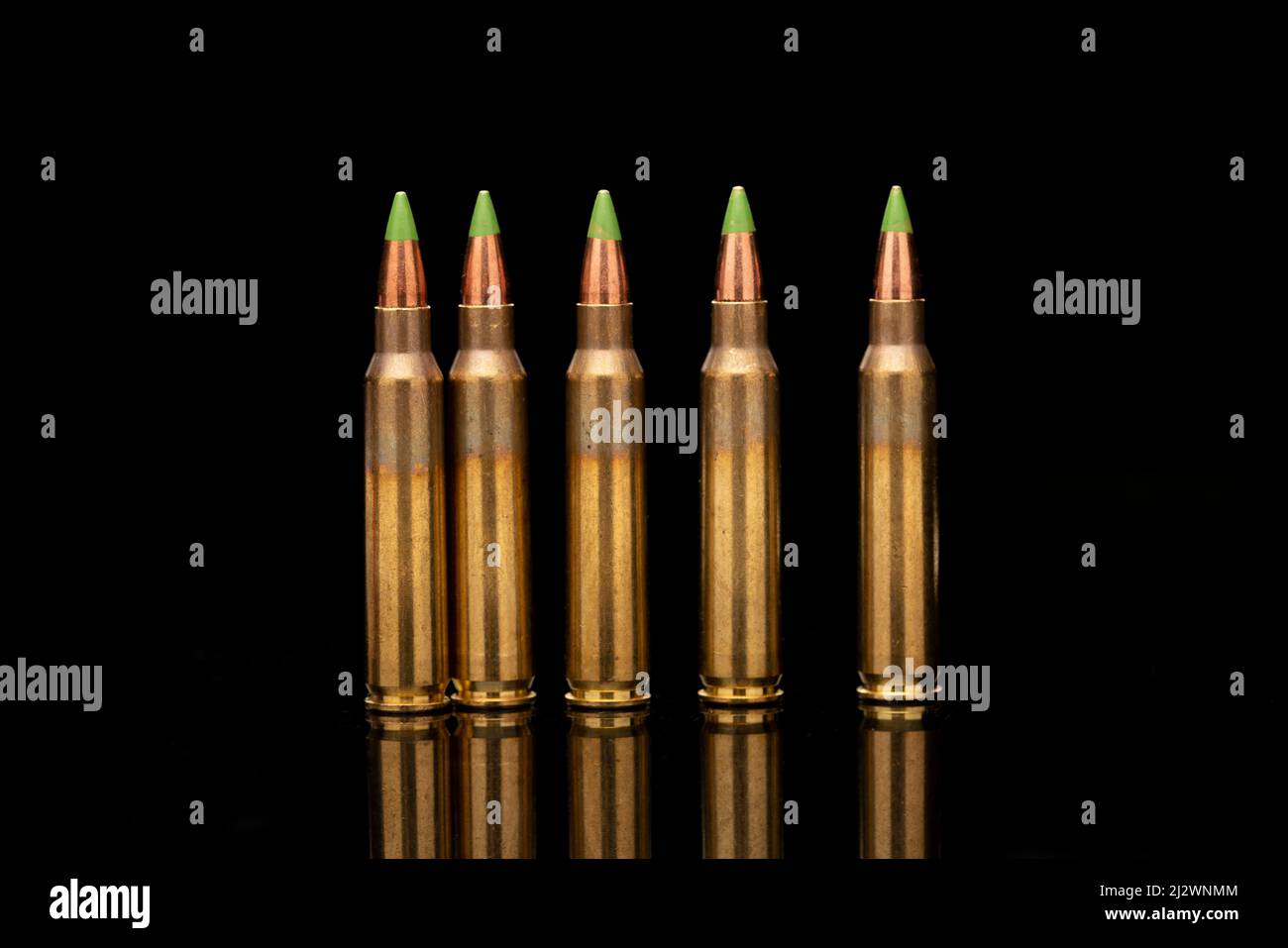 A group of 5.56 calibar, green tip bullets ordered into the line on ...