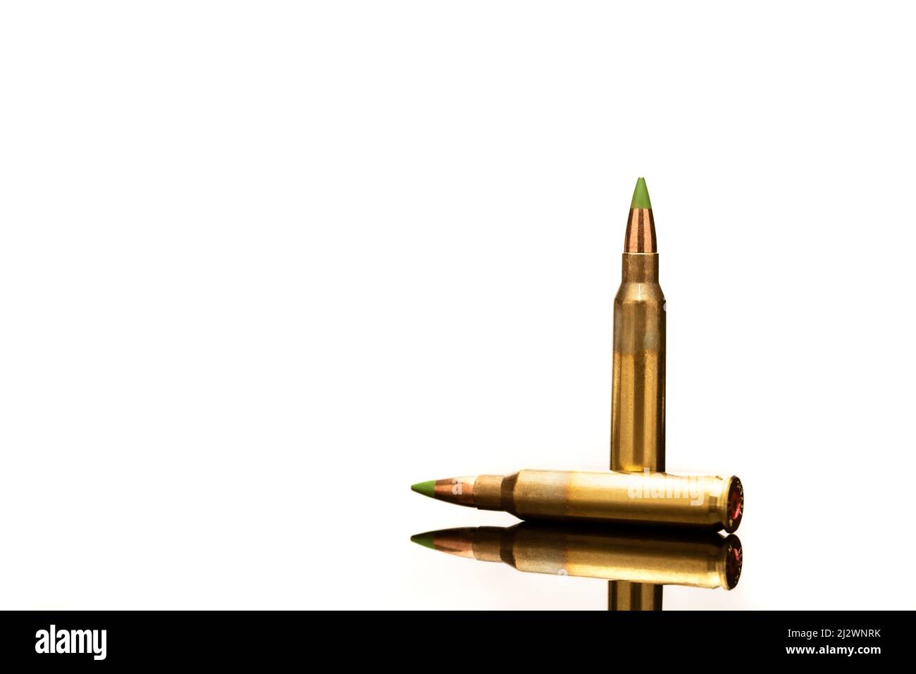 A pair of 5.56 calibar, green tip bullets on white background Stock ...