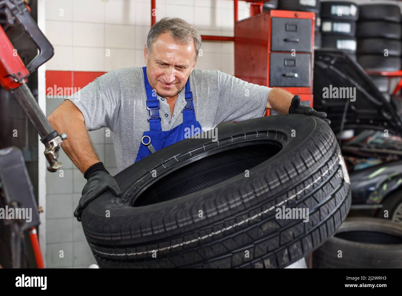 Car mechanician changing car wheel Stock Photo - Alamy