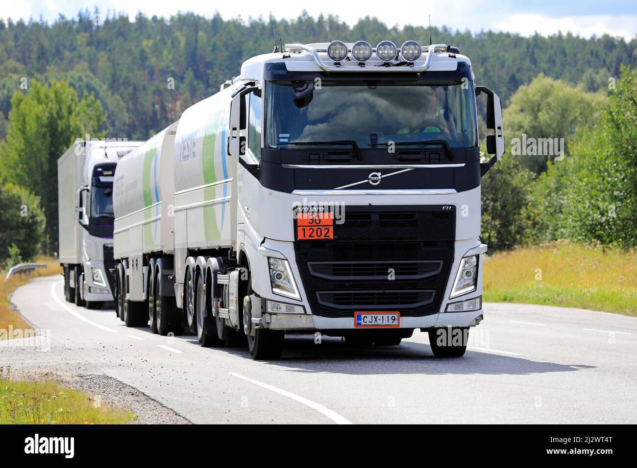 White Volvo FH tank truck hauls NESTE diesel fuel, ADR 30-1203, on road in the summer, Volvo ...