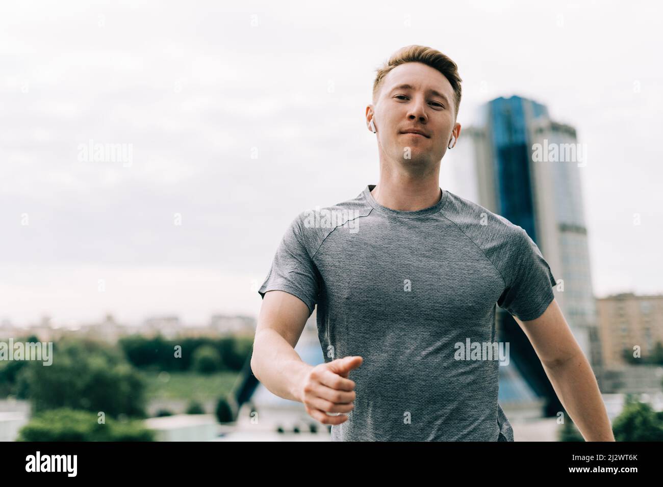 Young athlete man runner running up and down on city stairs in summer ...