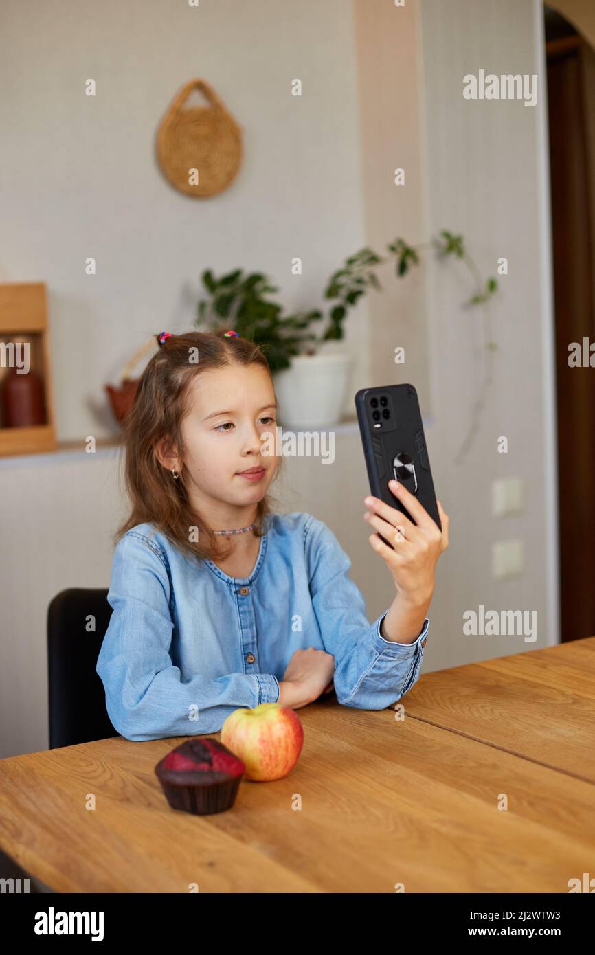 Happy smiling little girl holding smartphone having video call with ...