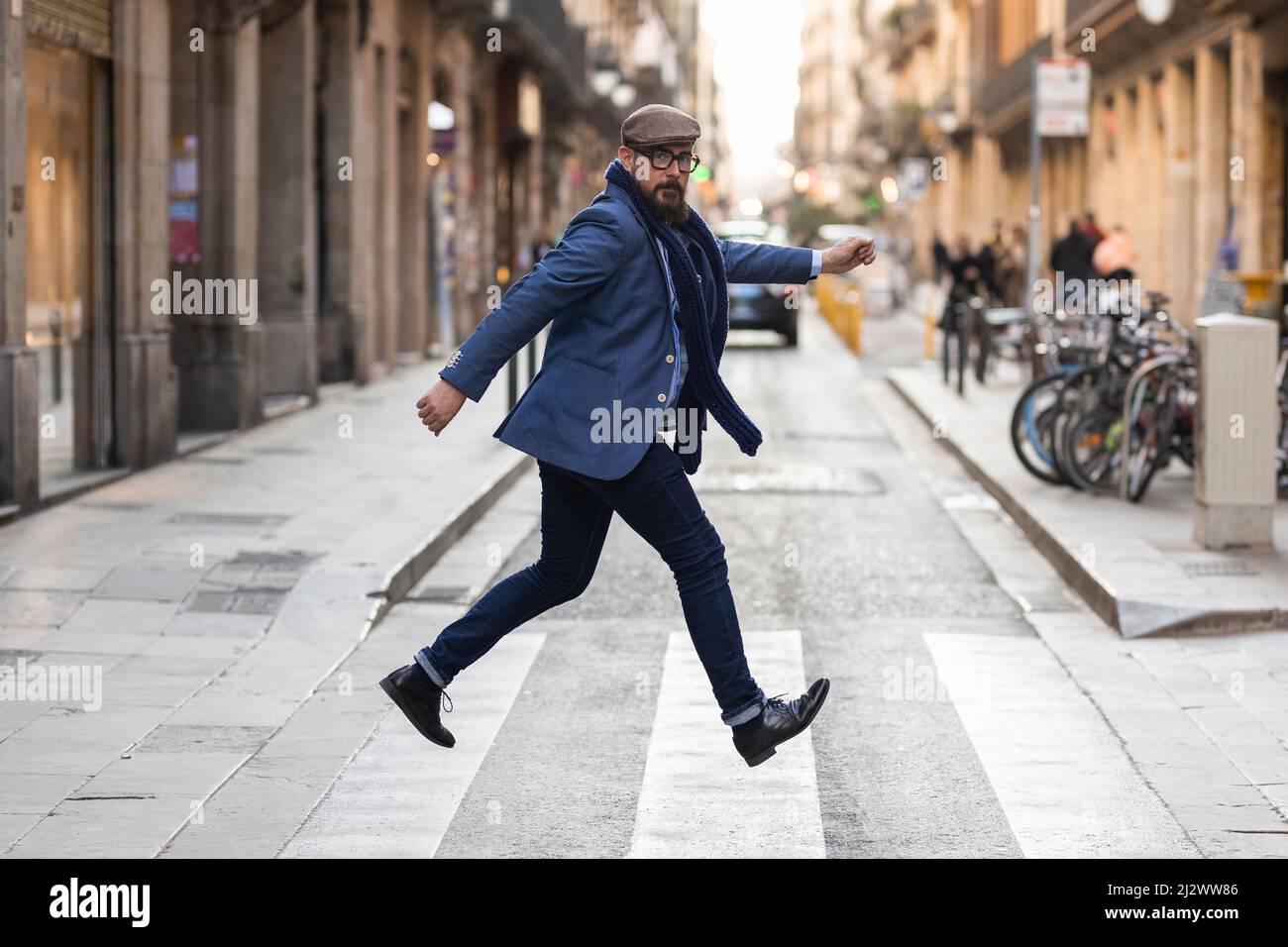 Adult man jumping in pedestrian crossing of street in Barcelona Stock ...