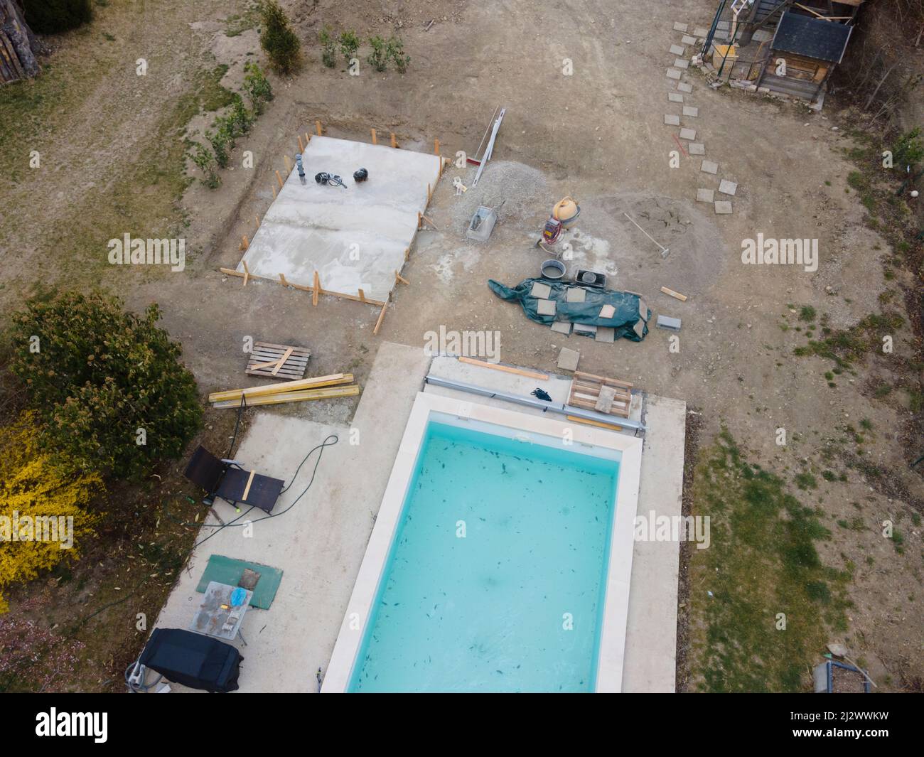 Drone shot of pool construction site with concrete pad for heat pump ...