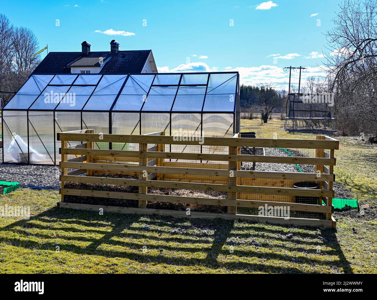 Compost greenhouse and house in springtime garden Stock Photo - Alamy