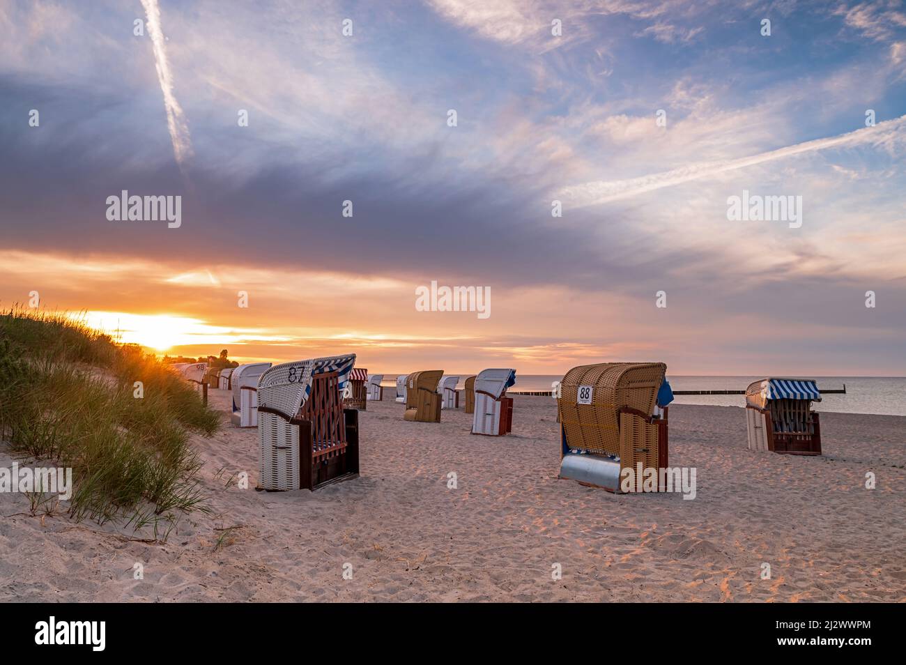 Beach chairs in front of the rising sun in Großenbrode, Baltic Sea ...