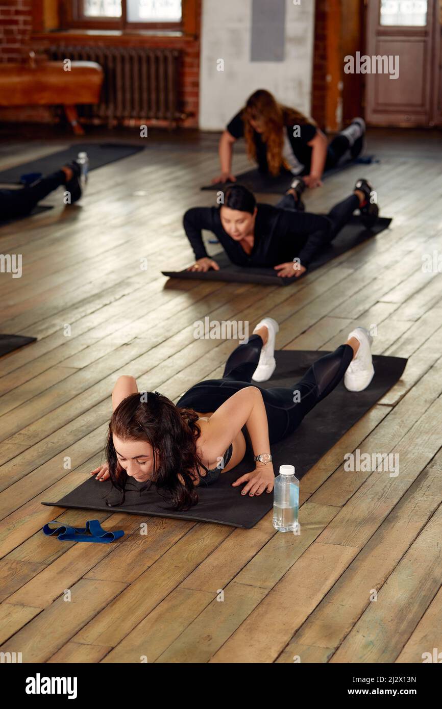 Small group of people with healthy habits doing stretching exercises on ...