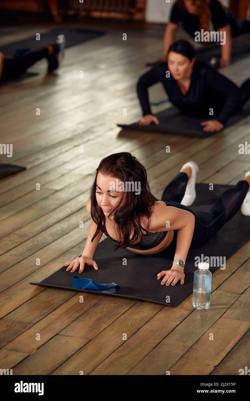 Small group of people with healthy habits doing stretching exercises on ...