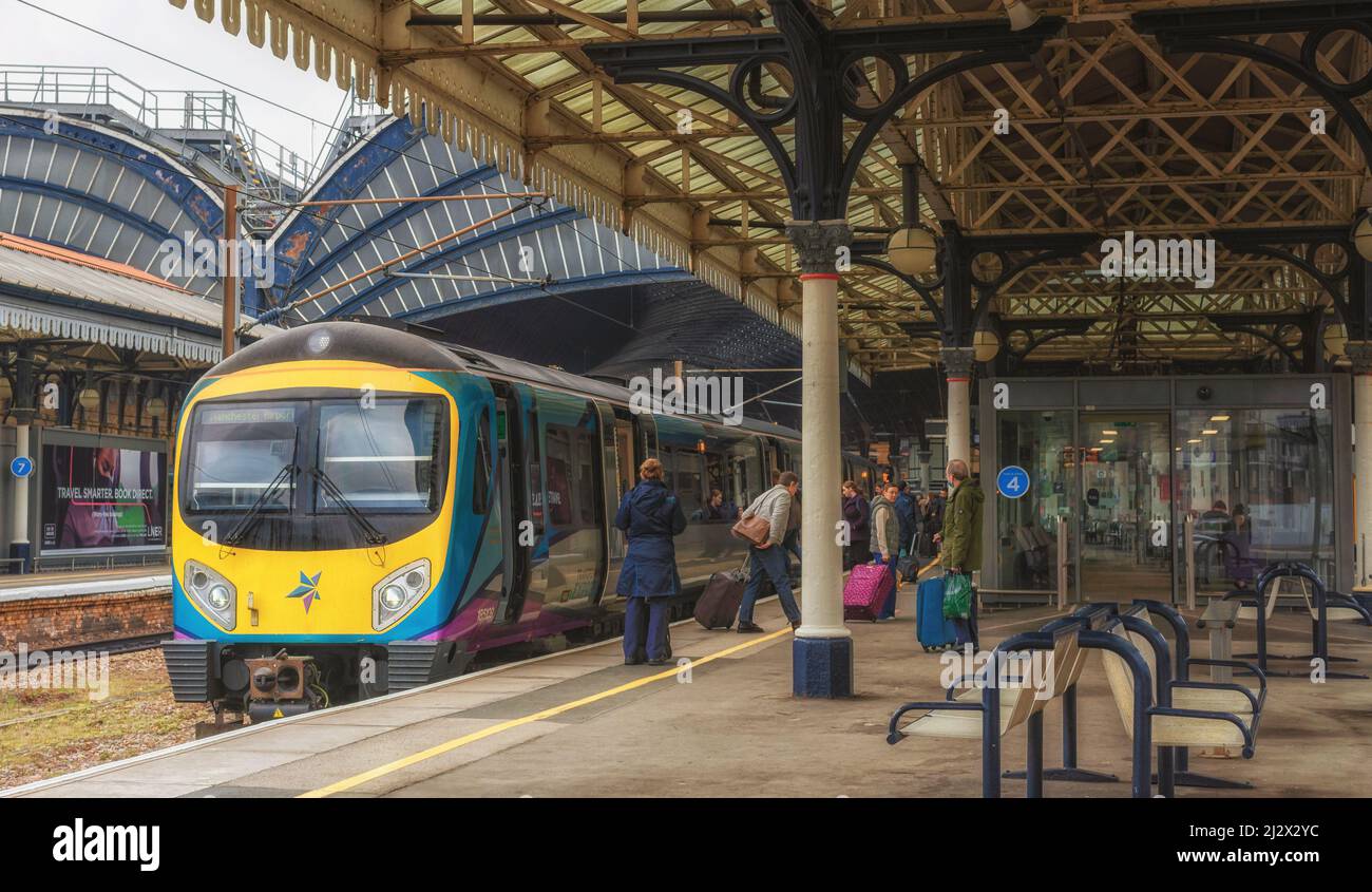 Railway station platform with a train alongside. Overhead is an ...