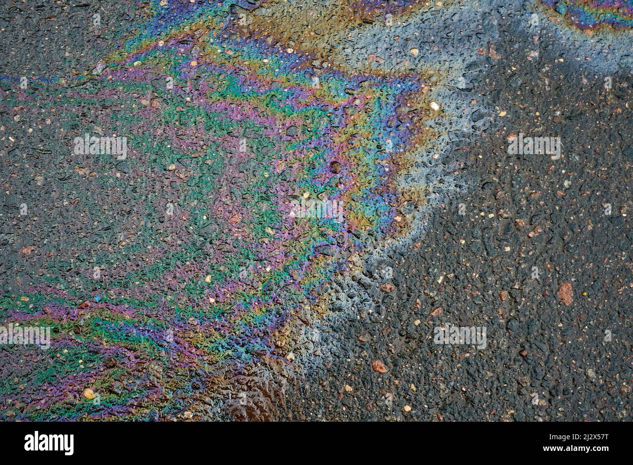 Oil slick on the asphalt road background. Rainbow gasoline oil spill on ...