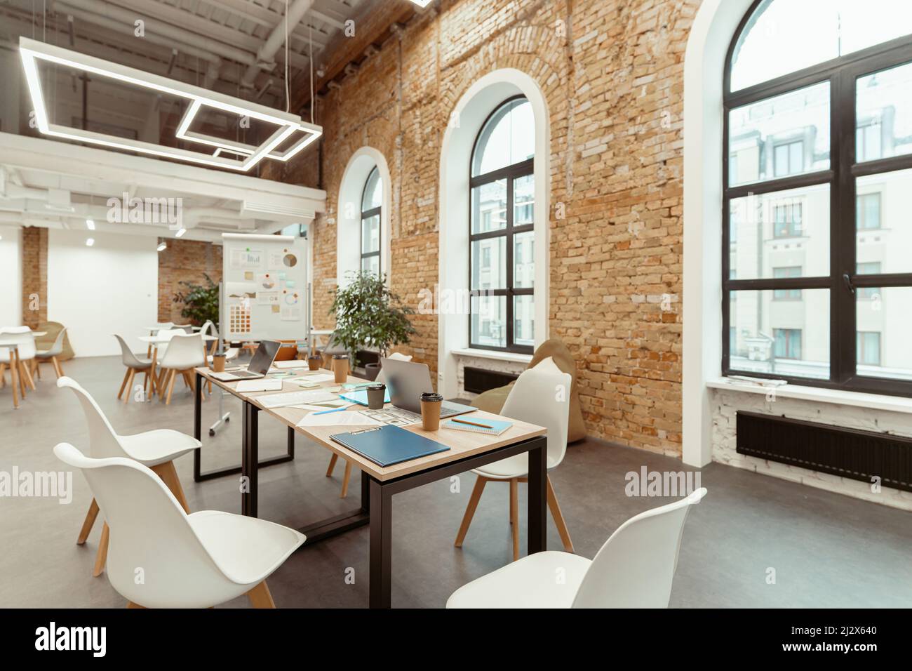 Empty work room in modern coworking in loft style Stock Photo - Alamy