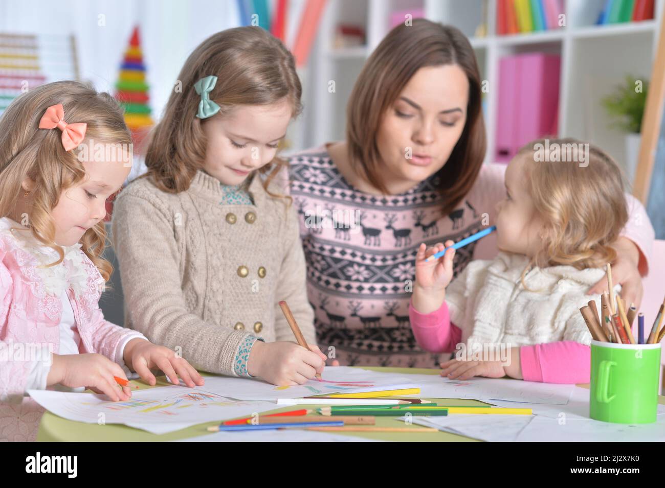 Mother and her three daughters drawing together Stock Photo - Alamy