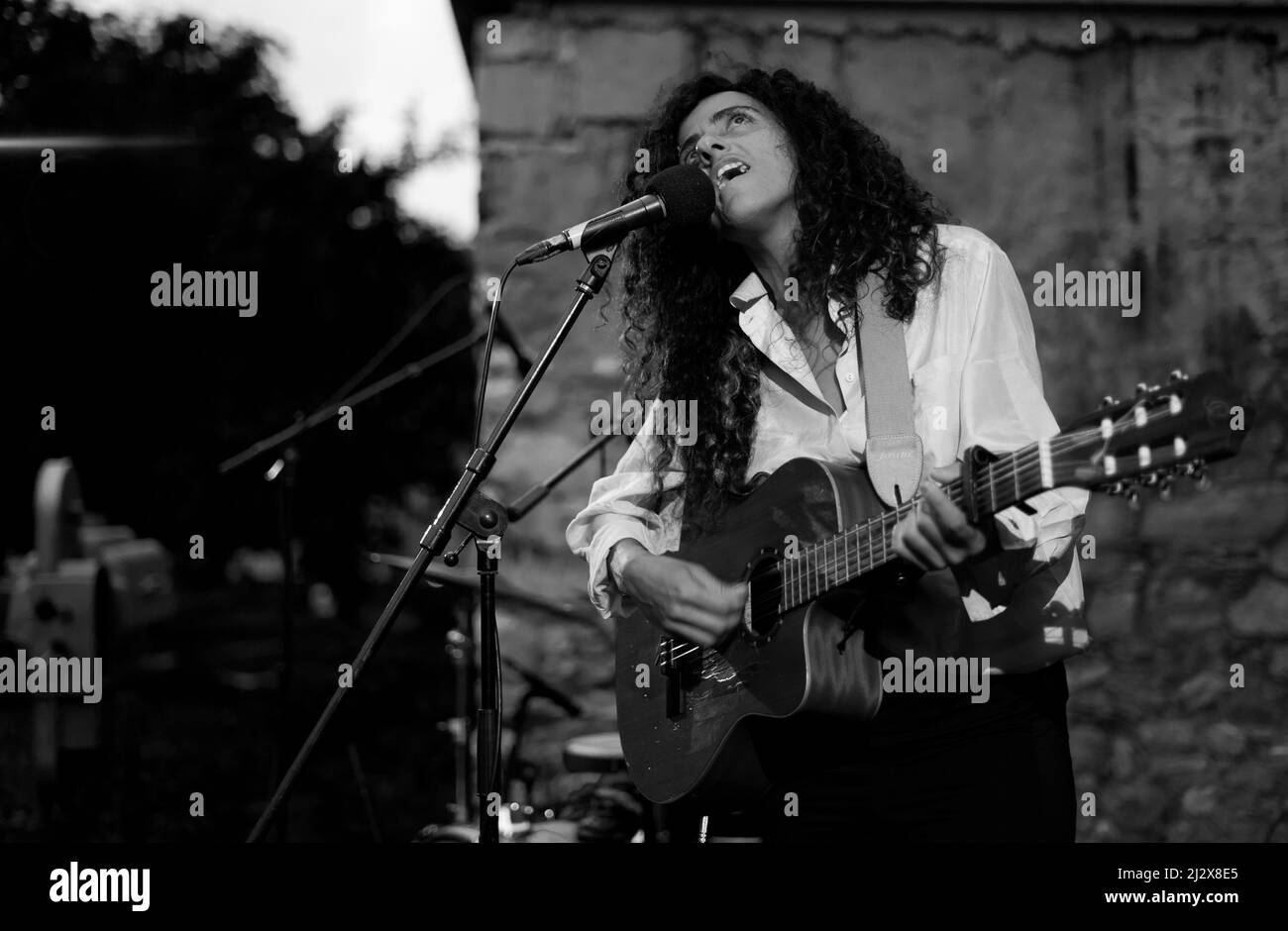 Young female singer singing and playing guitar in a live Stock Photo ...