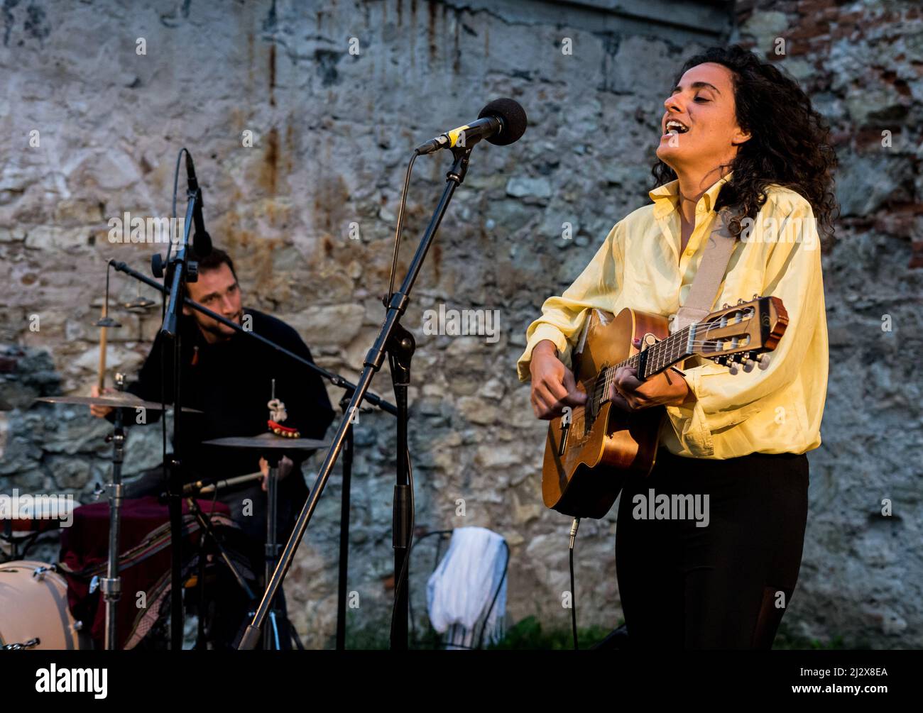 Young female singer singing and playing guitar in a live Stock Photo ...