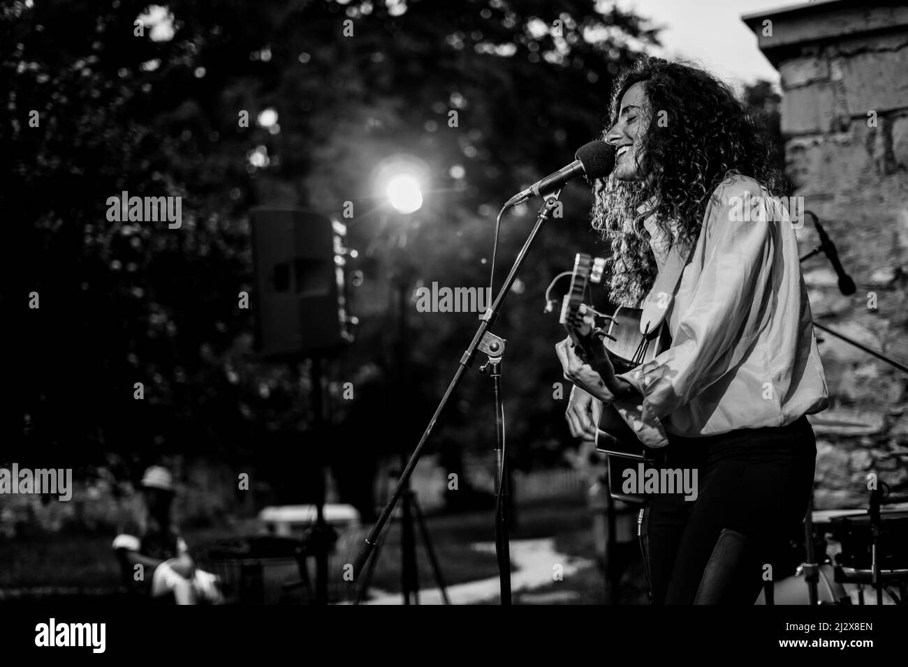 Young female singer singing and playing guitar in a live Stock Photo ...