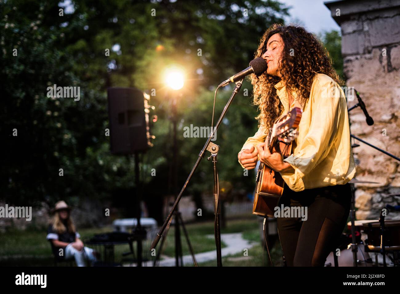 Young female singer singing and playing guitar in a live Stock Photo ...