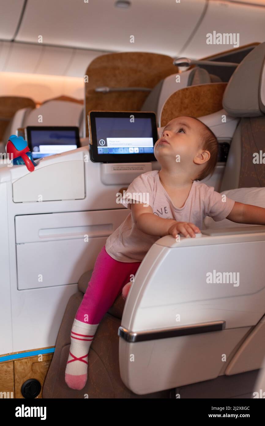 One-year-old toddler enjoying her first business class flight with many ...