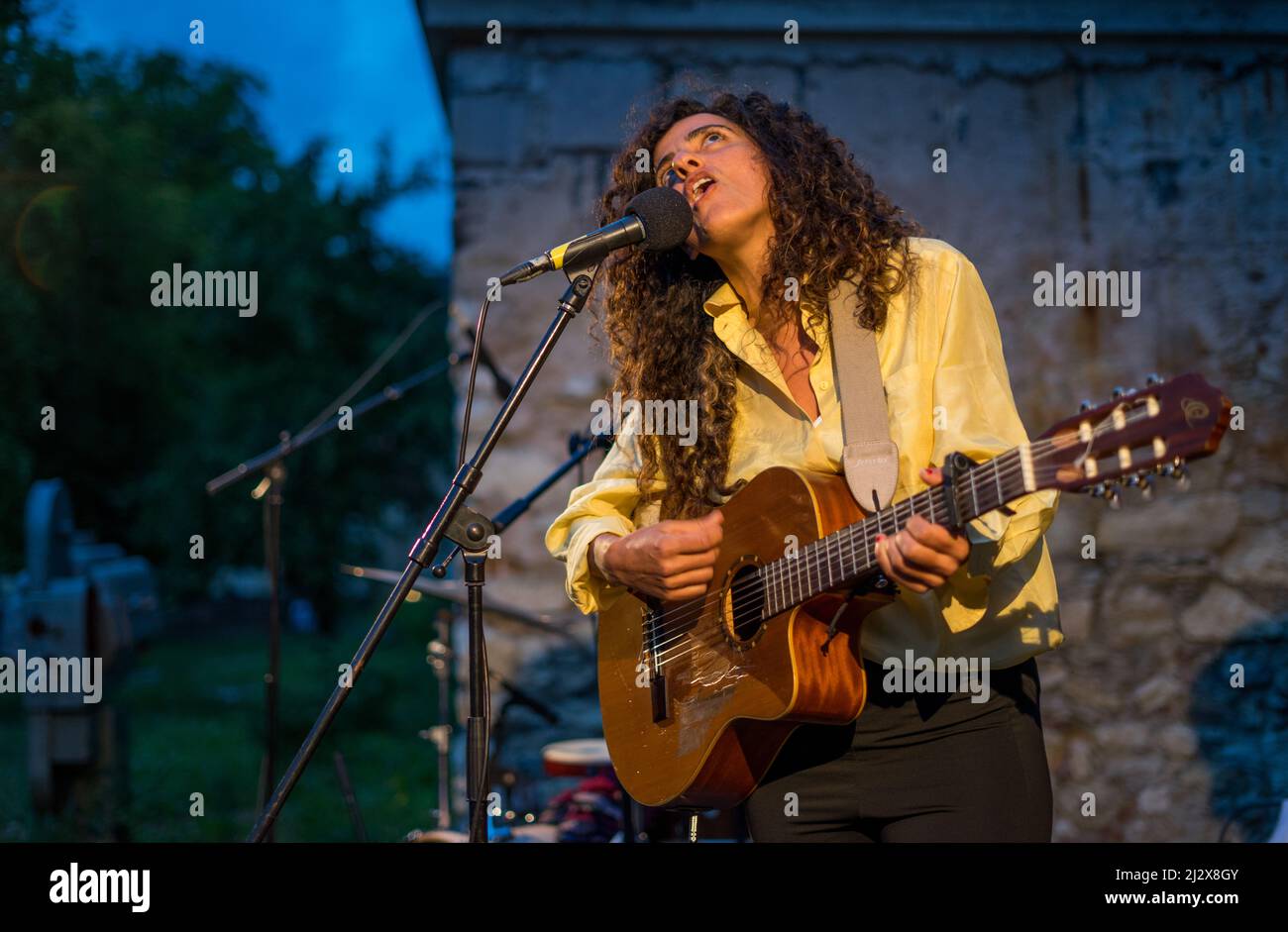 Young female singer singing and playing guitar in a live Stock Photo ...