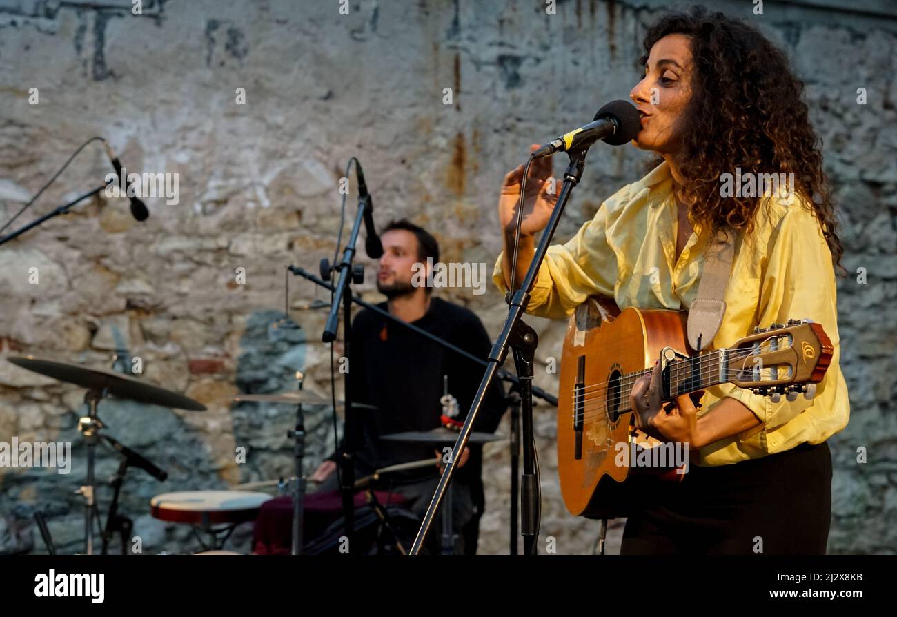 Young female singer singing and playing guitar in a live Stock Photo ...