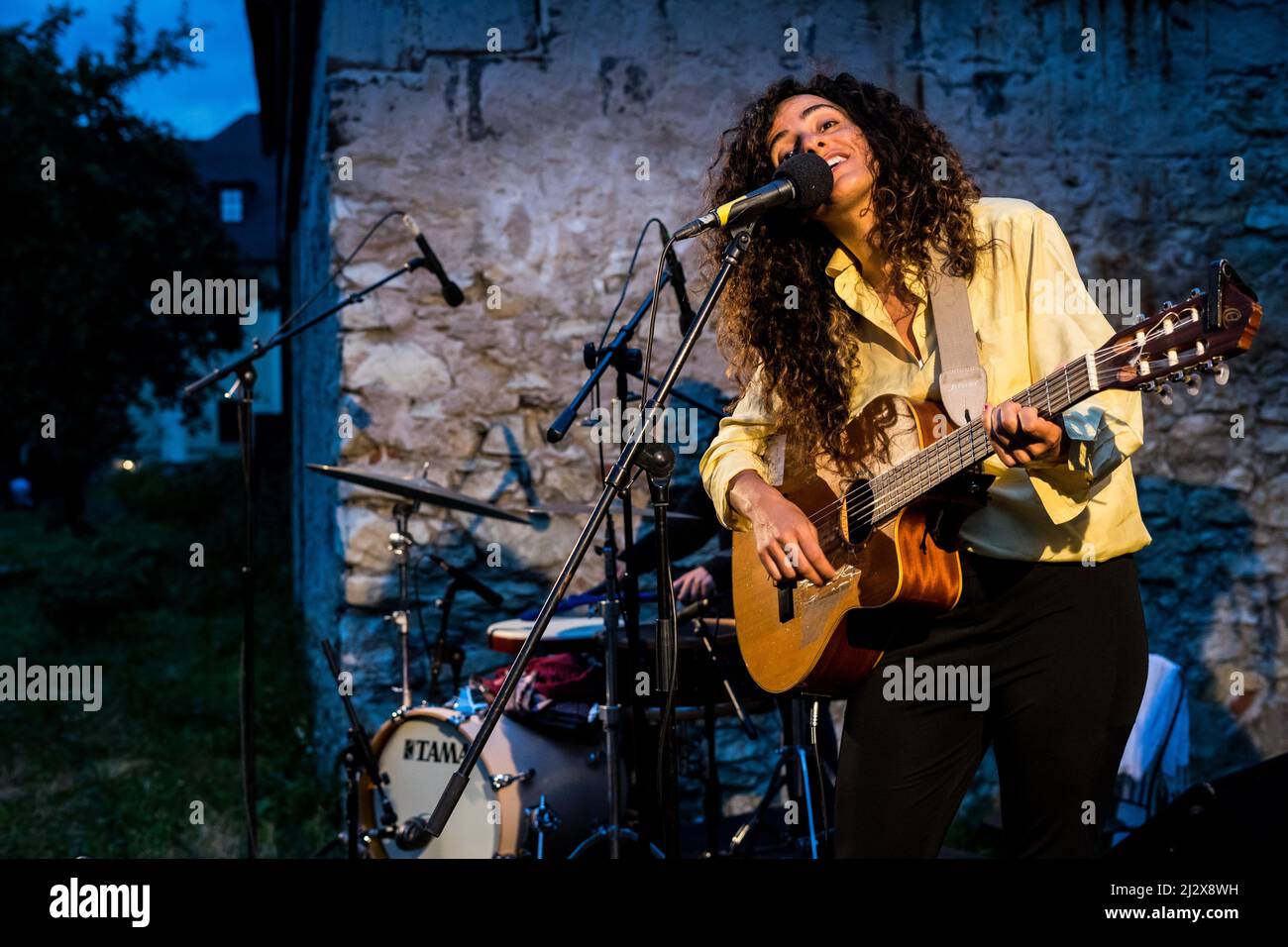 Young female singer singing and playing guitar in a live Stock Photo ...