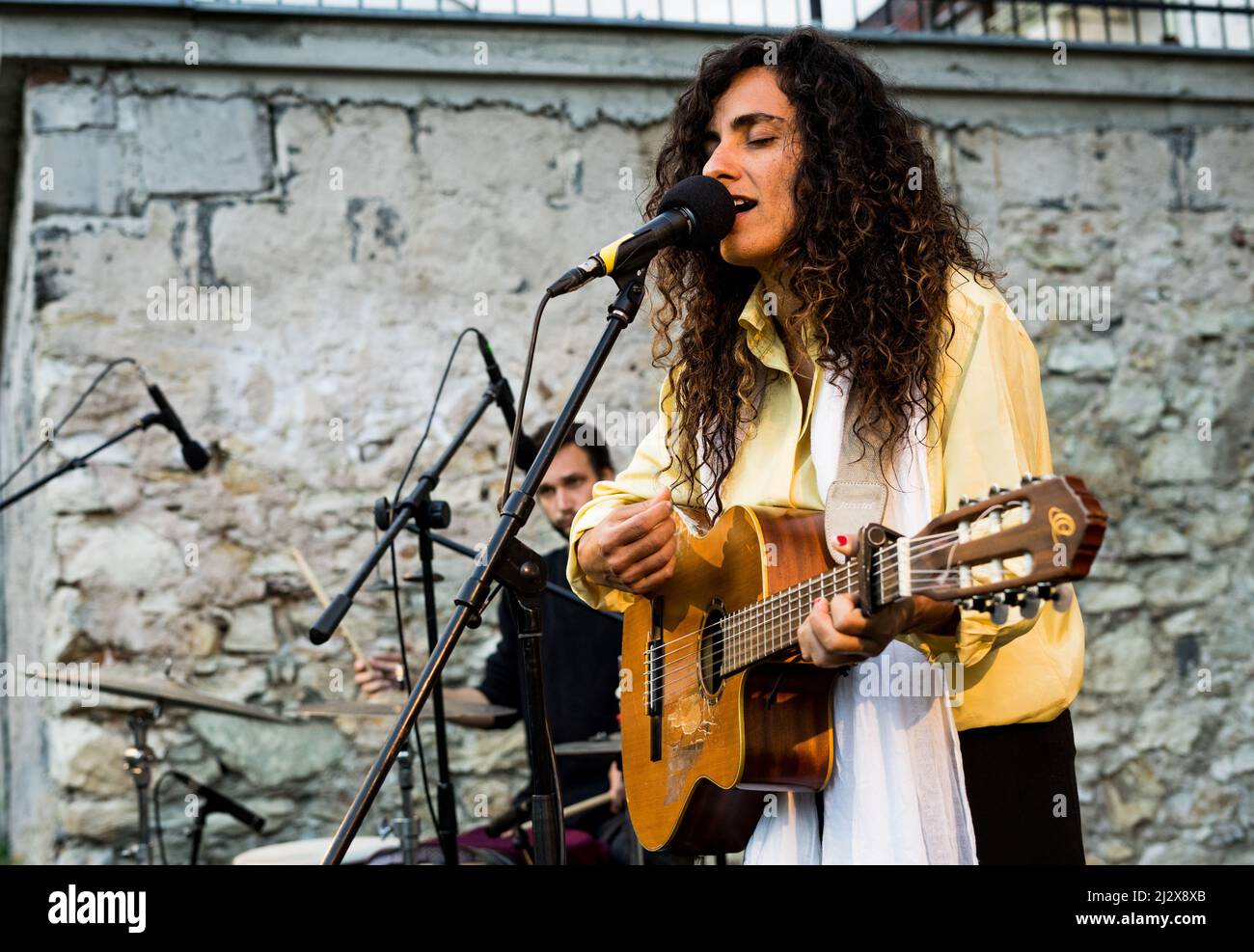 Young female singer singing and playing guitar in a live Stock Photo ...