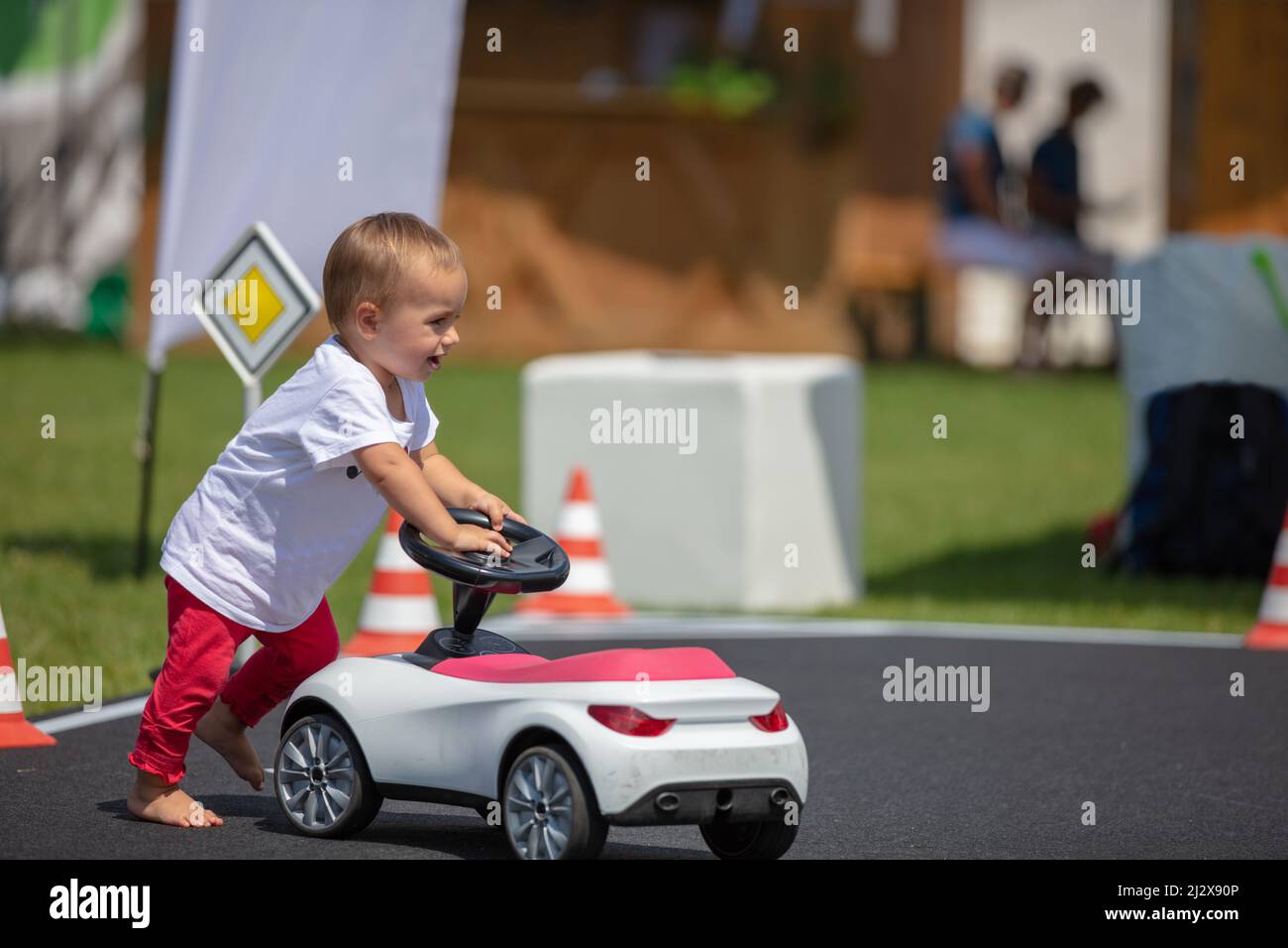 Toddler enjoying first traffic education on an outdoor practice ground ...