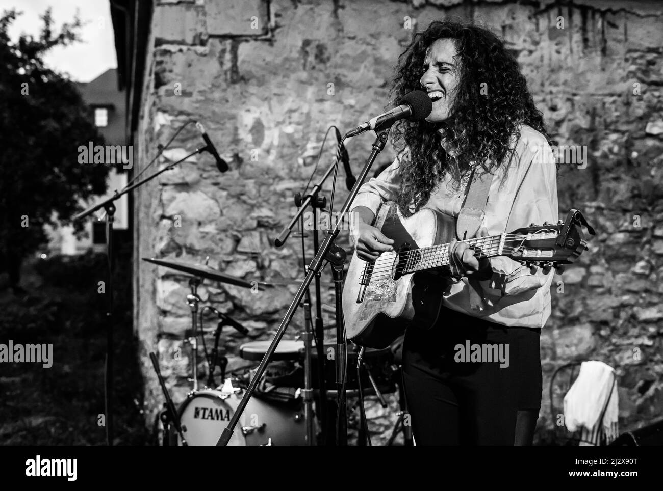 Young female singer singing and playing guitar in a live Stock Photo ...