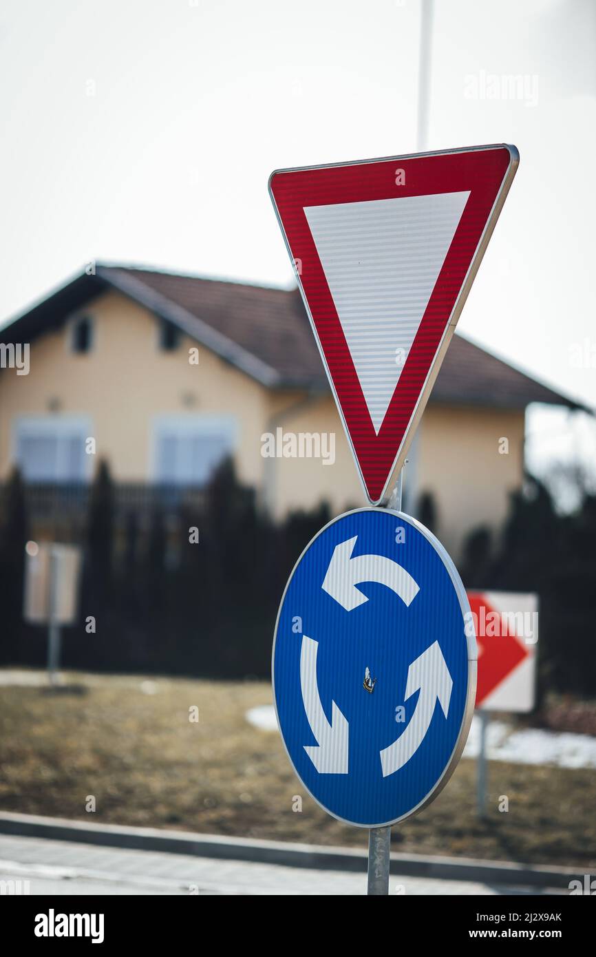 A Shallow focus Shot of traffic signs, a triangle marked in red and a ...