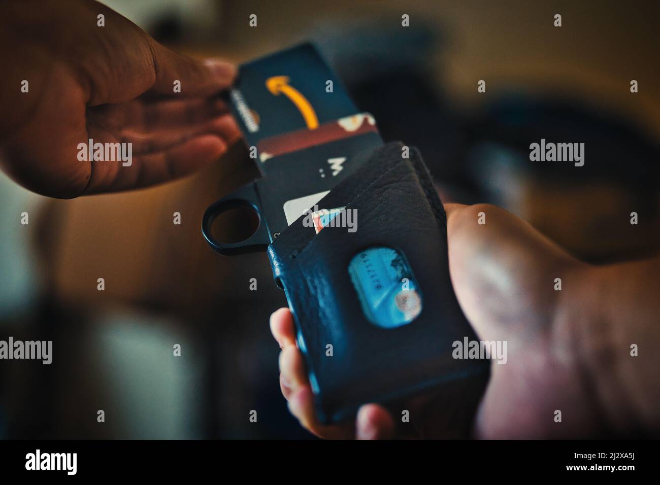 A closeup of a hand taking out of credit card from a Grip6 wallet on a ...