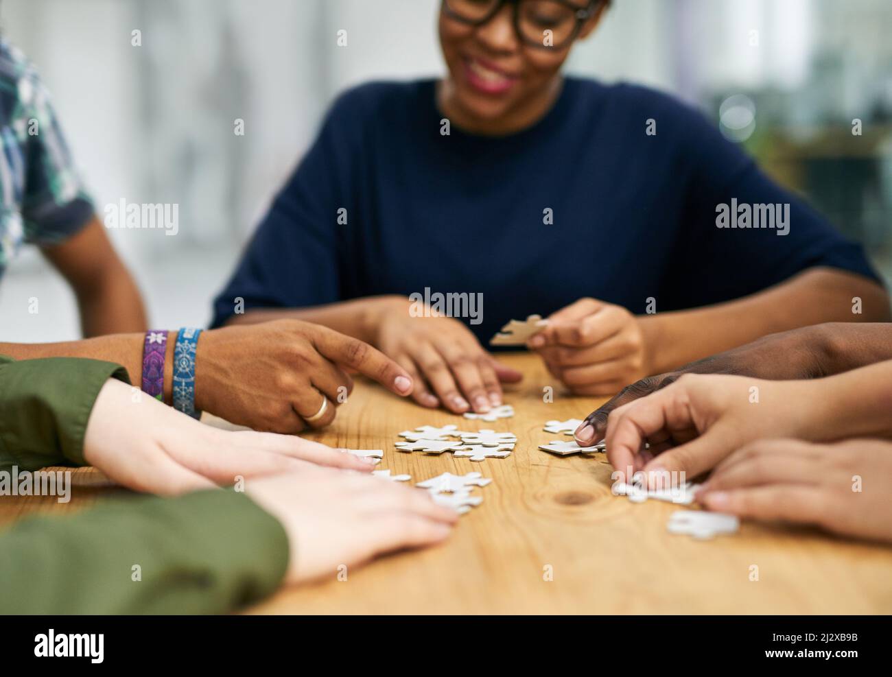 Building success together. Shot of a group of people building a puzzle ...