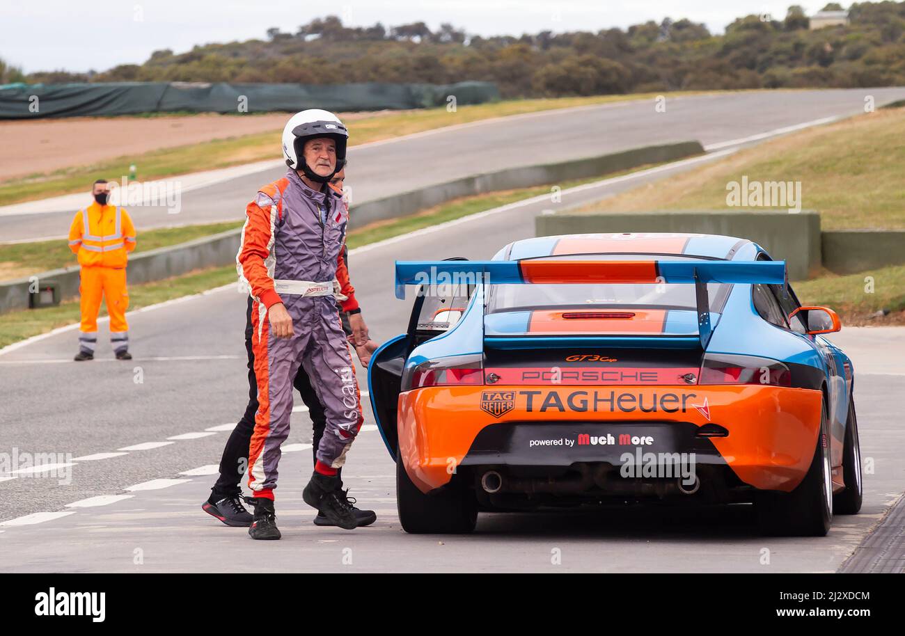 Race car driver walks past Tag Heuer Porsche 911 GT3 Cup Car in the ...