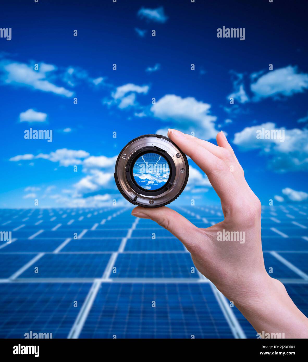 Hand holds optical lens on solar panels Stock Photo - Alamy