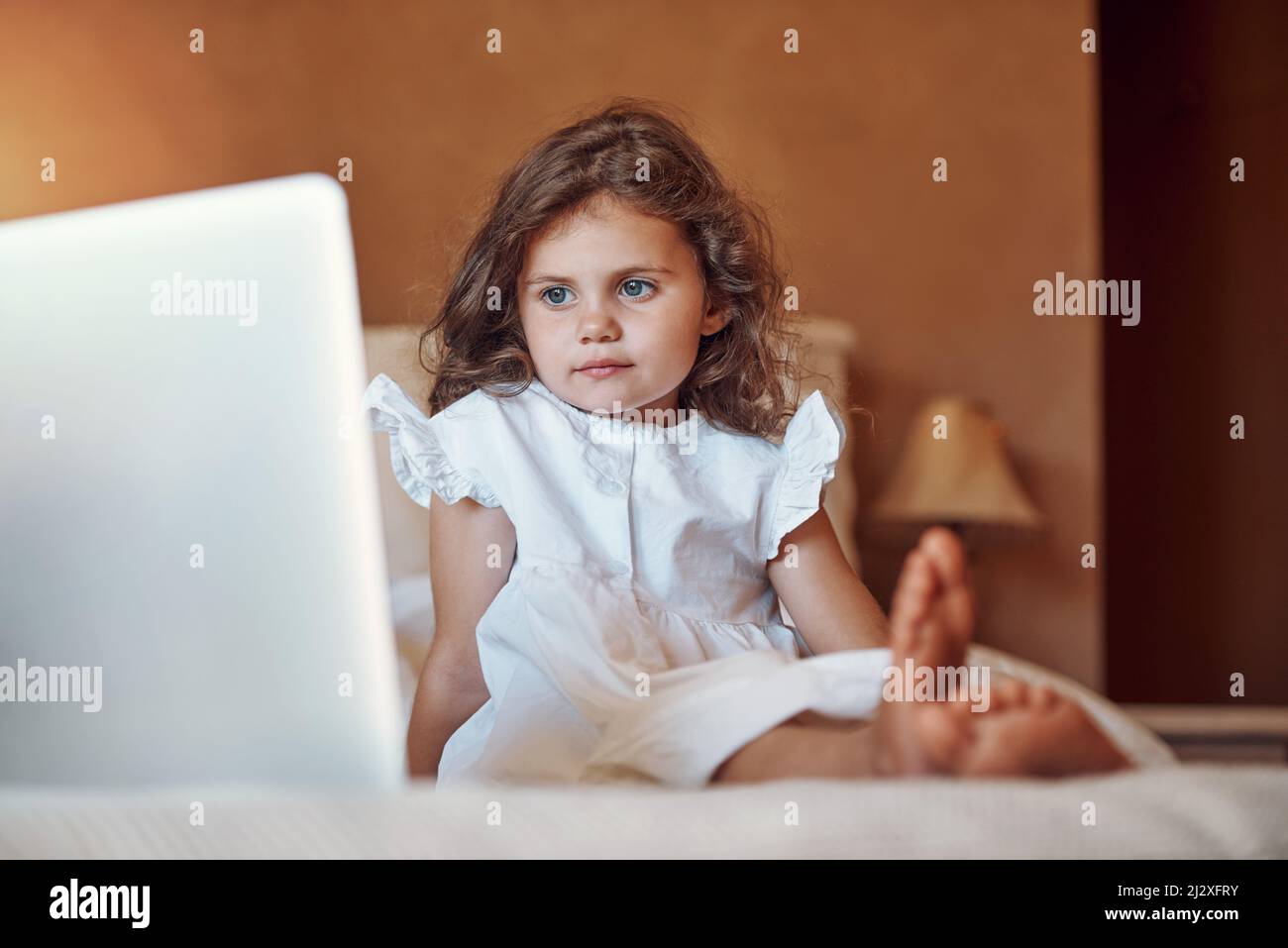 Catching up with her favourite cartoons. Shot of an adorable little ...
