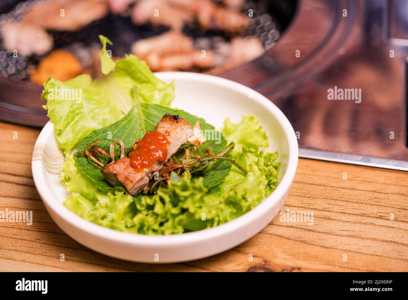 BBQ korean grill buffet. grilling meat wrap green vegetable leaf for ...