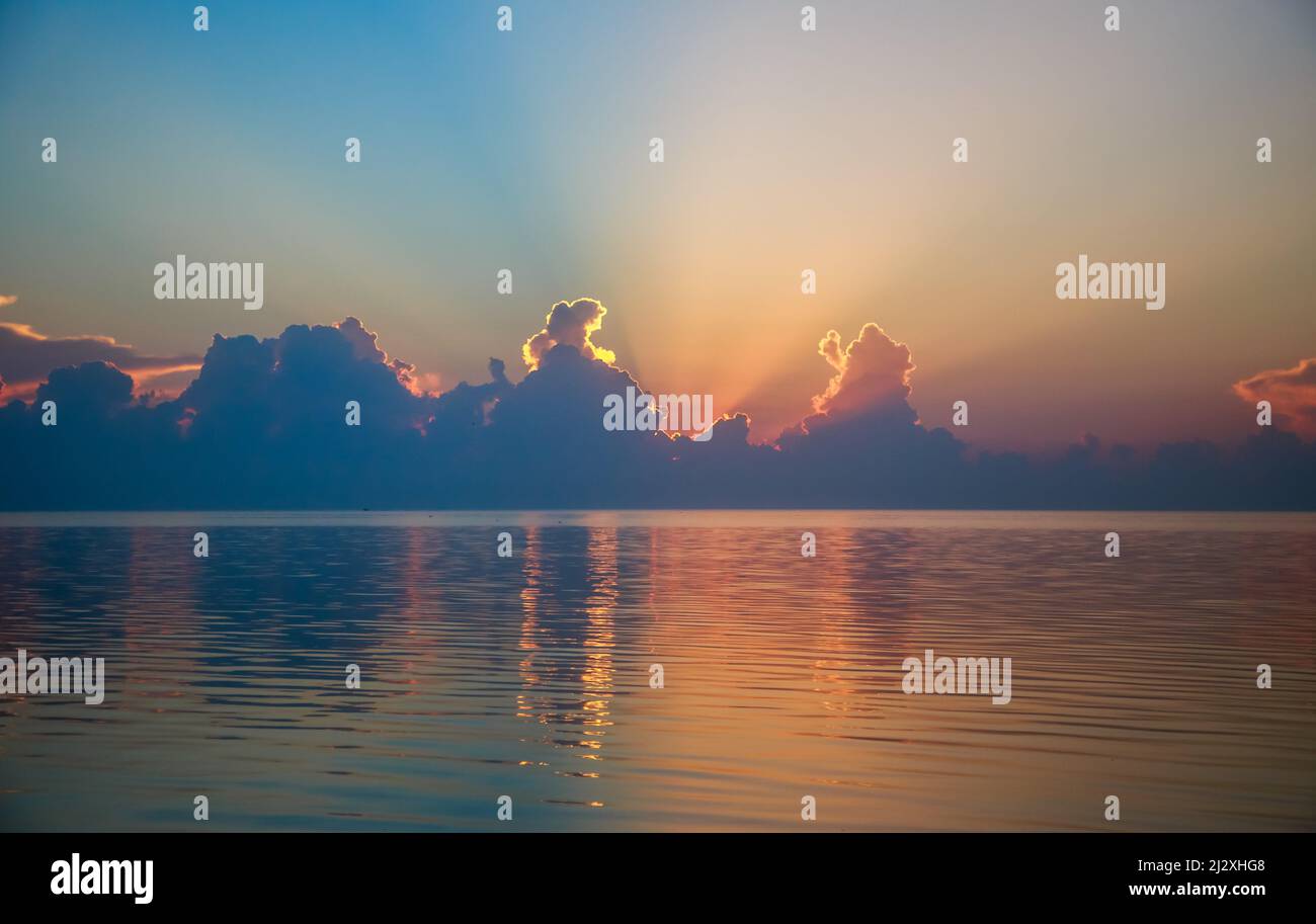 A seascape with the fairy sunset background reflected in the water ...