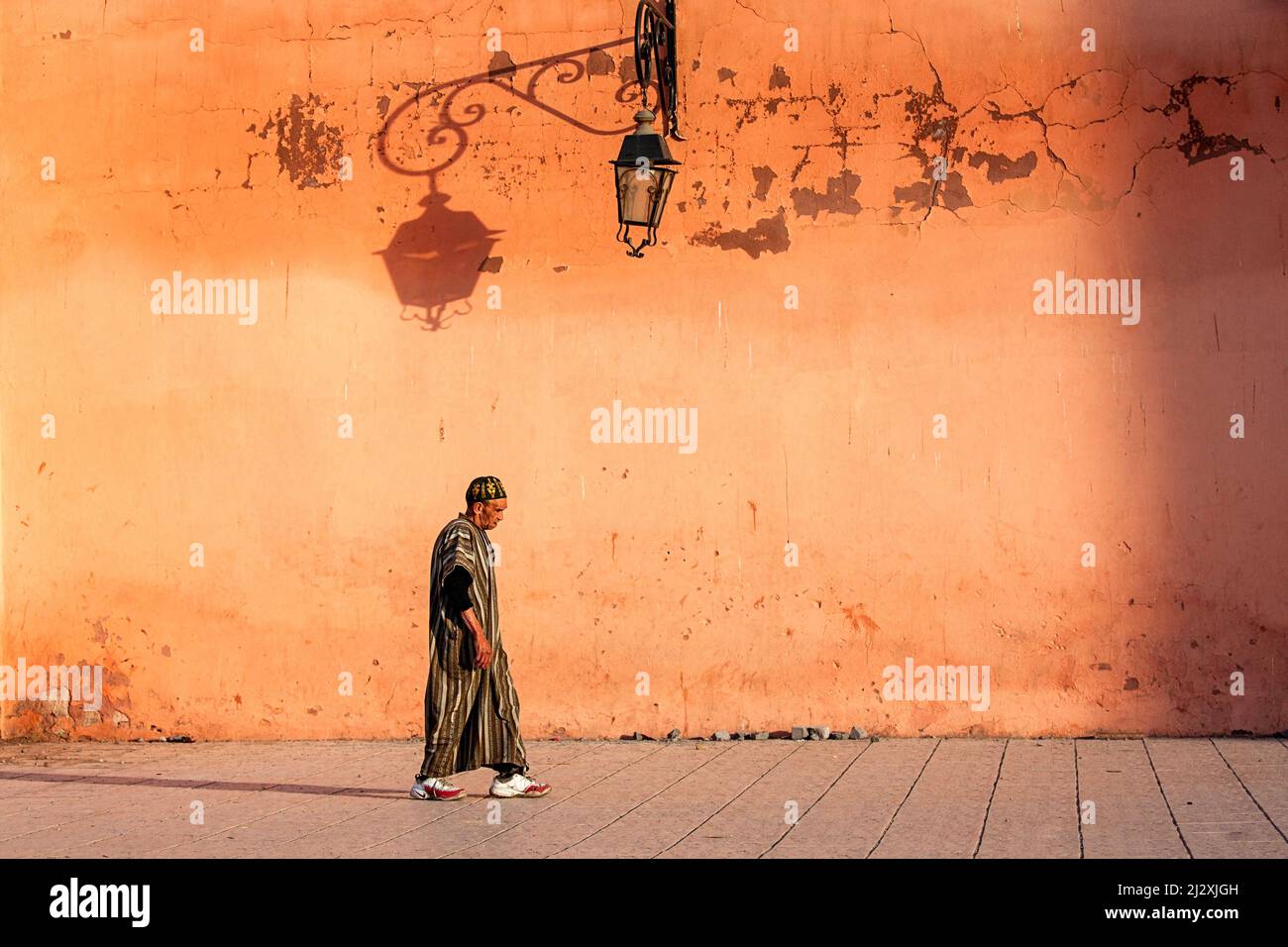 Local men dressed in traditional dress djellaba walking on the street ...