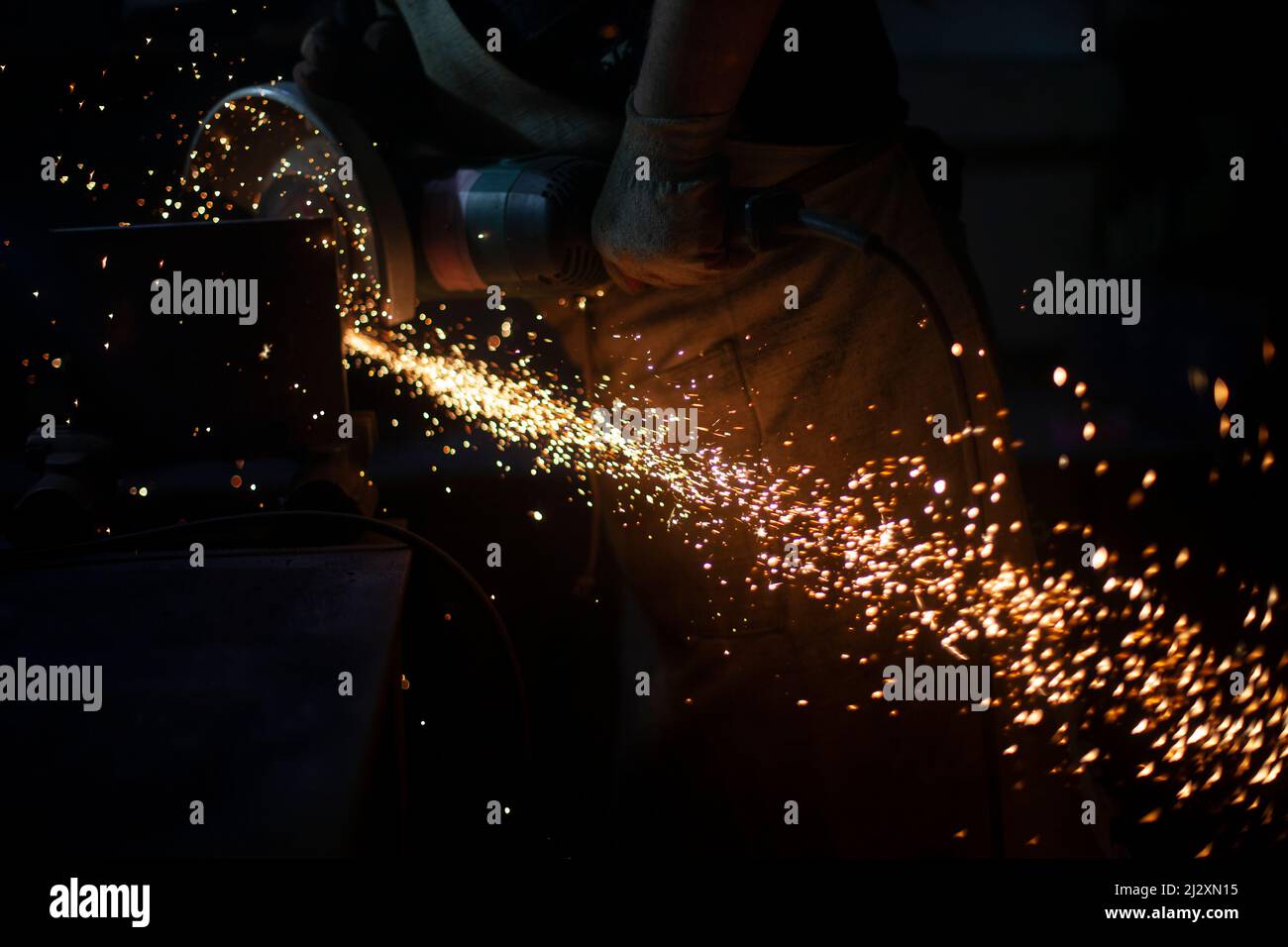 Work as grinder in workshop. Metal grinding. Sparks from high ...