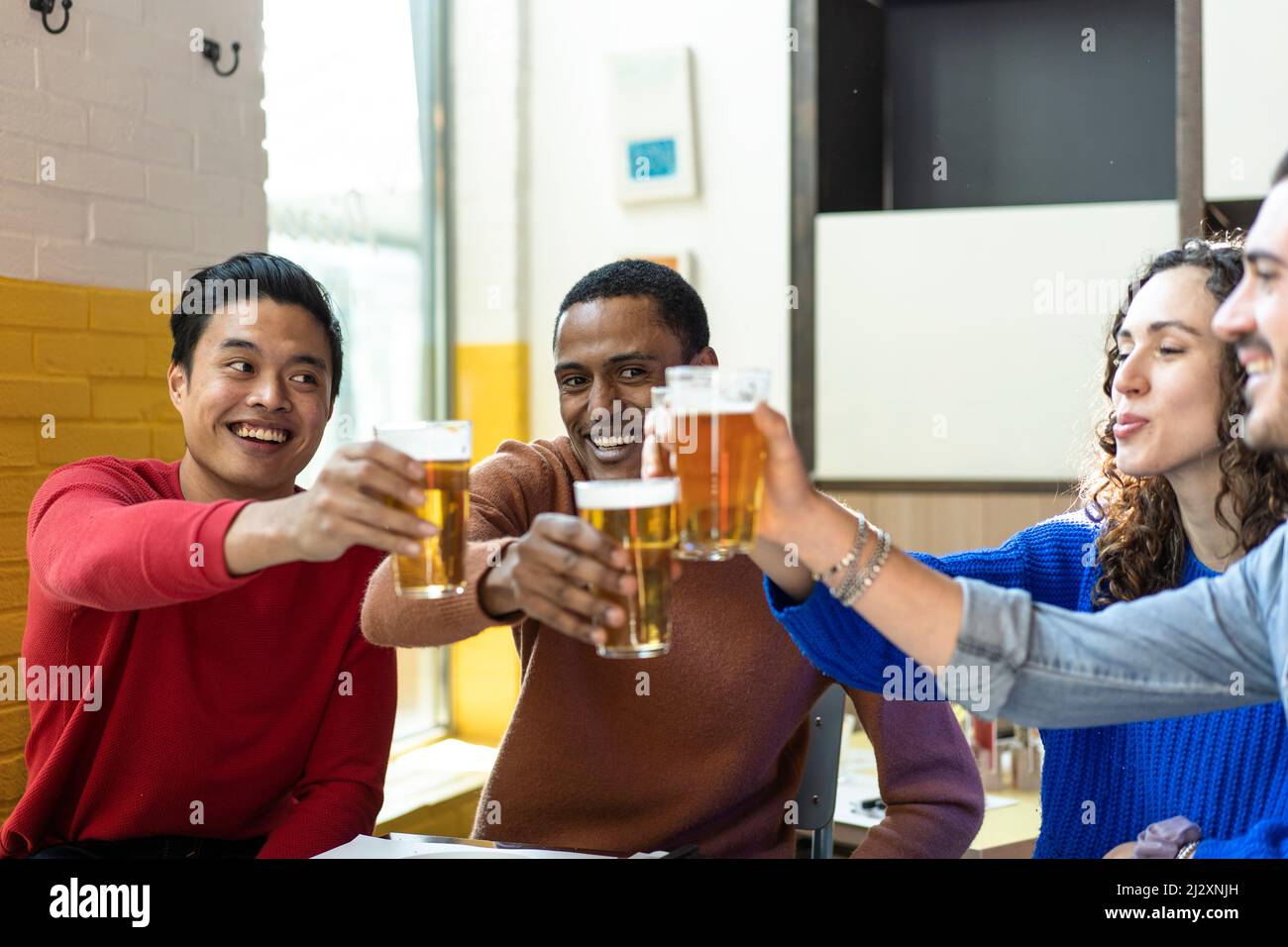 Multiethnic friends drinking beer at brewery bar restaurant on weekend ...