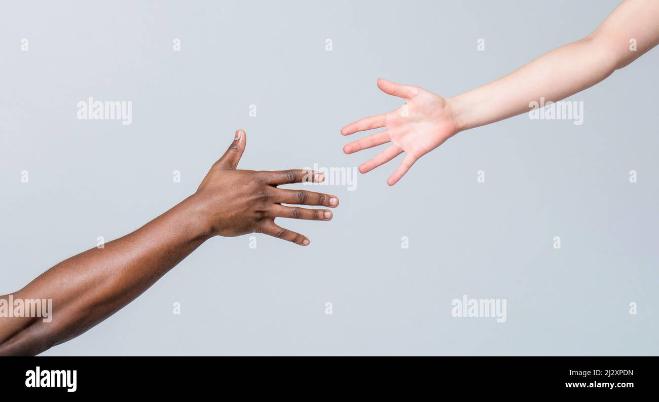 Giving a helping hand to another. Woman and african woman hand. Helping ...